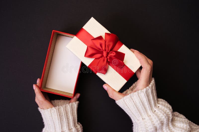 Hands with Knitted Sleeves Hold Open Gift Box on Black Background Stock ...