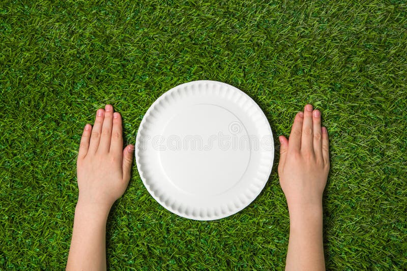 Hands Lying Near Empty Paper Plate on Green Grass Stock Image - Image ...