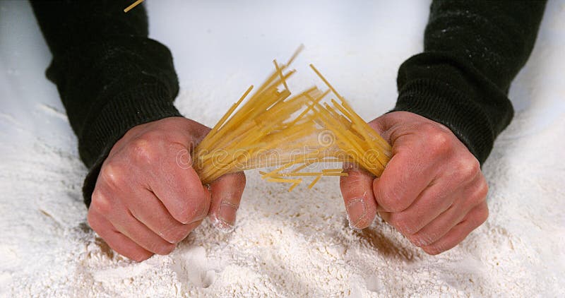 Hands of Man Breaking Spaghetti Pasta Against Flour Background Stock ...