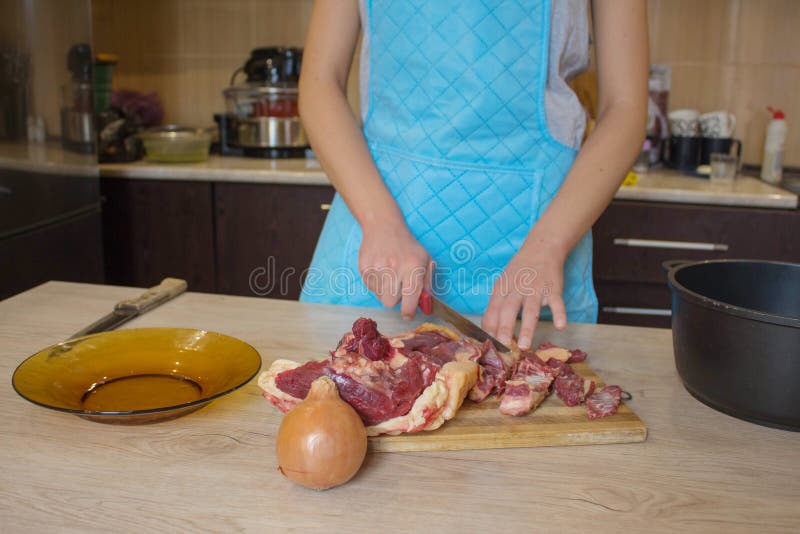 Hands of a Man Preparing Meat and Vegetables in a Kitchen. Focus on ...