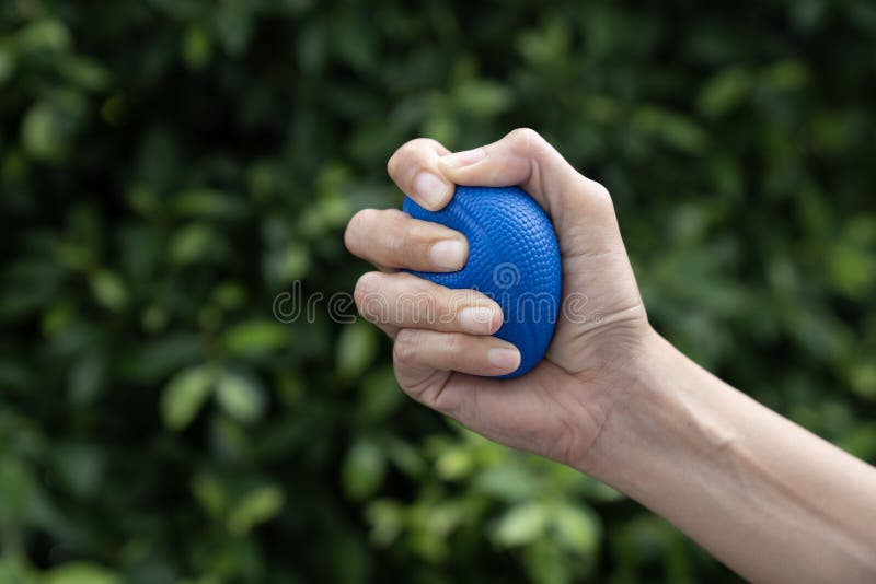 Hands of a Man Squeezing a Blue Stress Ball Stock Photo - Image of ...