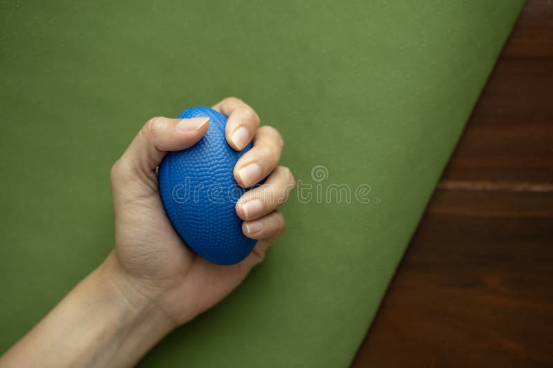 Hands of a Man Squeezing a Blue Stress Ball on the Yoga Mat Stock Image ...
