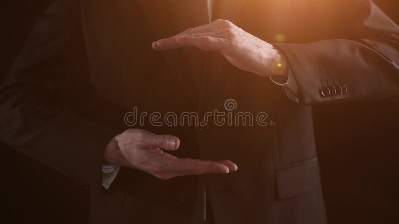 The Hands of a Man in a Suit Shows a Triangle Sign on a Black ...
