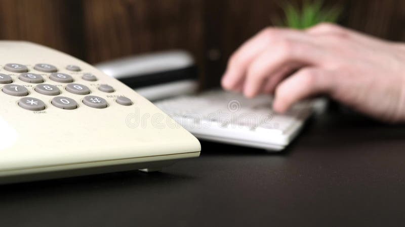 Hands of a Man is Using a Computer, Typing on Keyboard, Call the Phone ...