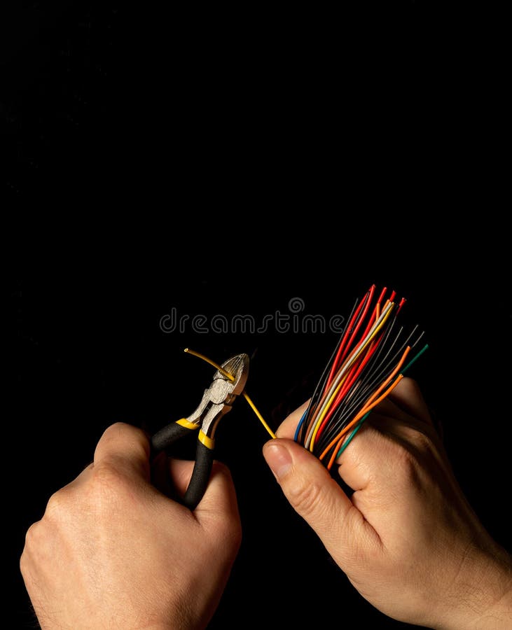 Hands of the Master Hold Wire Cutters and Wire Closeup on Black ...