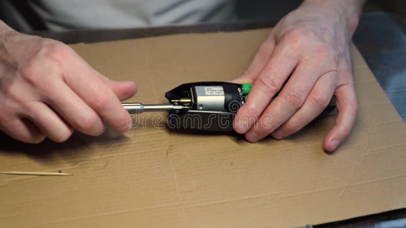 The Hands of the Master with a Screwdriver Twist the into the Mechanism ...