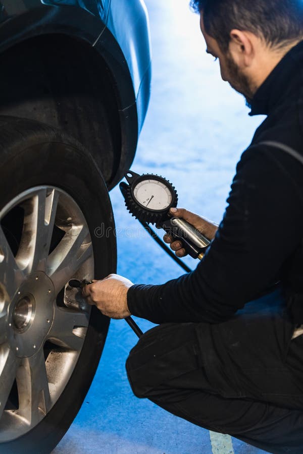 Hands of a Mechanic Inflating a Car Tire in His Workshop Stock Image ...