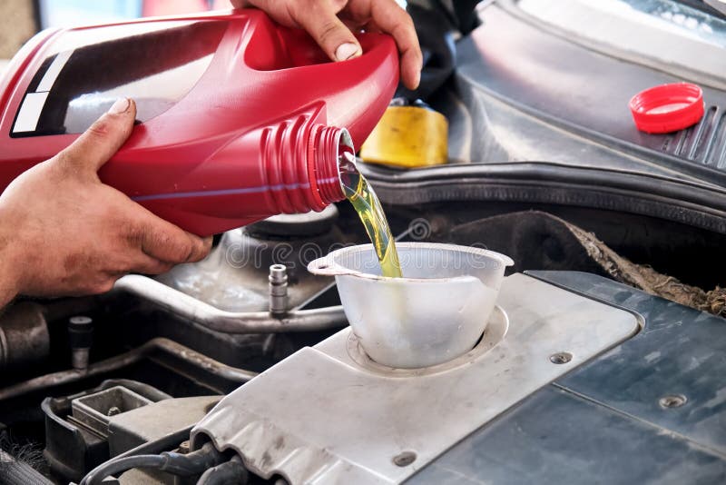 Hands of a Mechanic Repairman Adding or Pouring Oil To the Car Engine ...