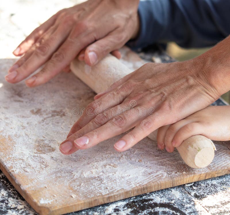 The Hands of the Mother and Child Roll Out the Dough with a Rolling Pin ... The Hands of the Mother and Child Roll Out the Dough with a Rolling Pin ...