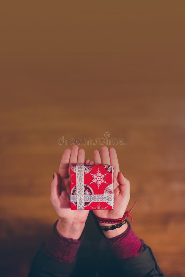 Hands Offering Christmas Gift Wrapped in Red Paper with Area for Text ...