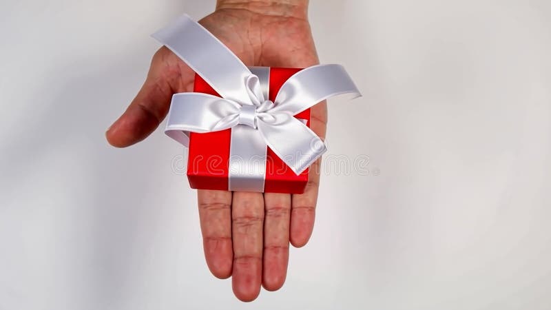 Hands Offering a Small Red Gift Box with White Ribbon on White ...