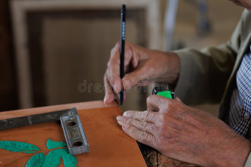 Hands of an Older Man, Working on Embossed Leather, and Taking Notes ...