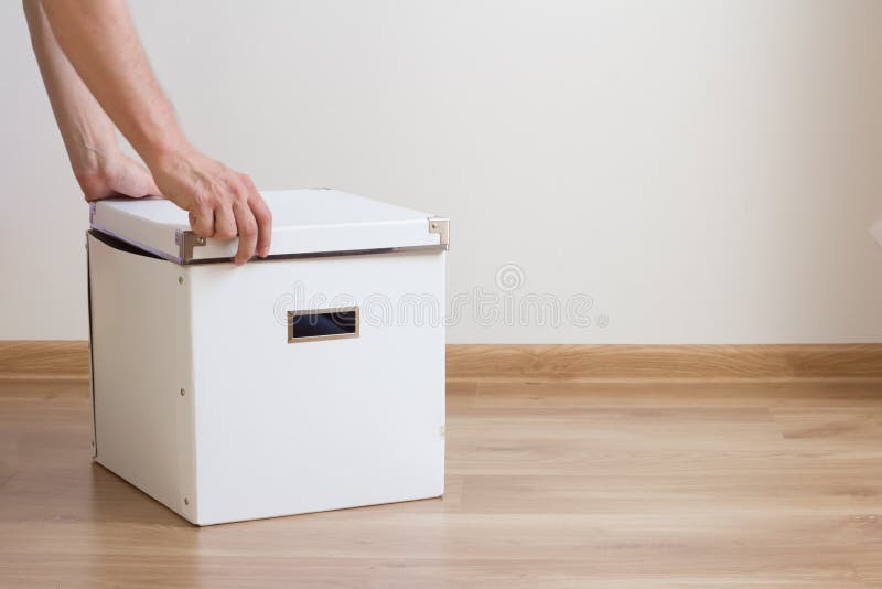 Hands Opening White Box on the Floor of Empty Room Stock Photo - Image ...