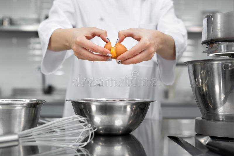 Hands of a Pastry Chef Break an Egg in a Professional Kitchen Stock ...