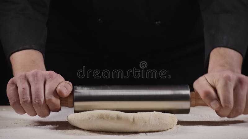 Hands of a Person Rolling Out Dough on a Kitchen Table Using a Metal ...