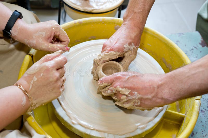 The Hands of a Potter Sculpting a Piece of Clay on a Rotating Potter S ...