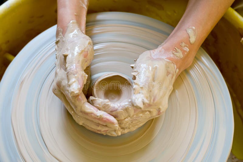 The Hands of a Potter Sculpting a Piece of Clay on a Rotating Potter S ...