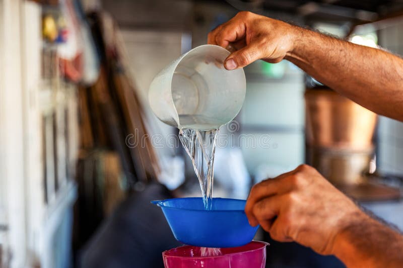 Pouring Liquid through Funnel into Colored Containers Stock Image ...