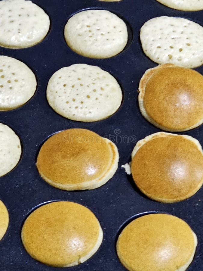 Hands Preparing Mini Pancakes in a Mold, they are Turned Over so that ...