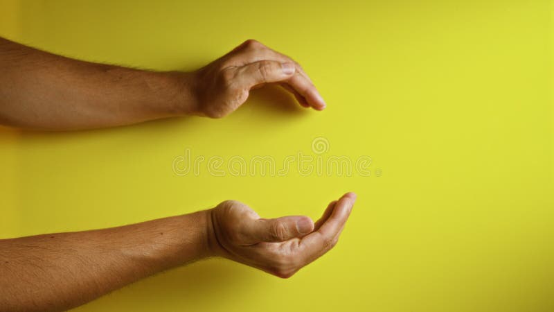 Hands Preparing To Hold Invisible Object Against Vivid Yellow ...