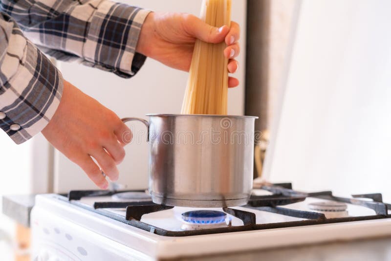 Hands Put the Bunch of Spaghetti Pasta in the Cooking Pan in Kitchen ...