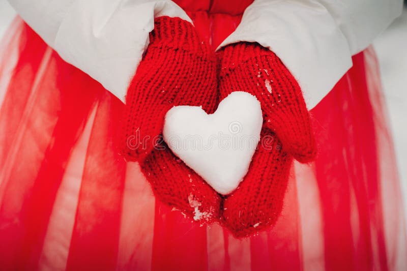 Hands in Red Mittens Close-up Holding a Heart Made of Snow.a Heart Made ...