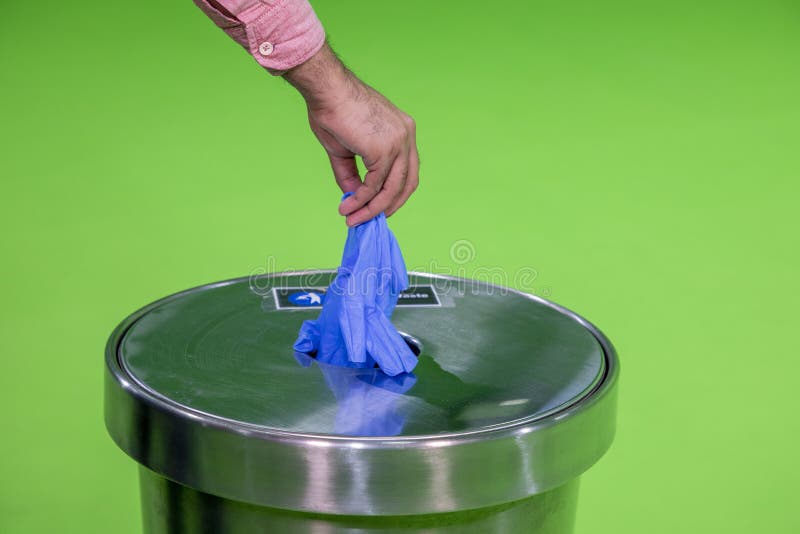 Hands Remove Glove on Green Background and Dump into Trash Can. Stock ...