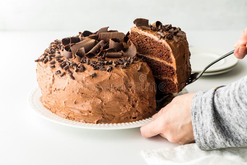 Hands Removing a Slice from a Triple Layered Homemade Chocolate Cake ...