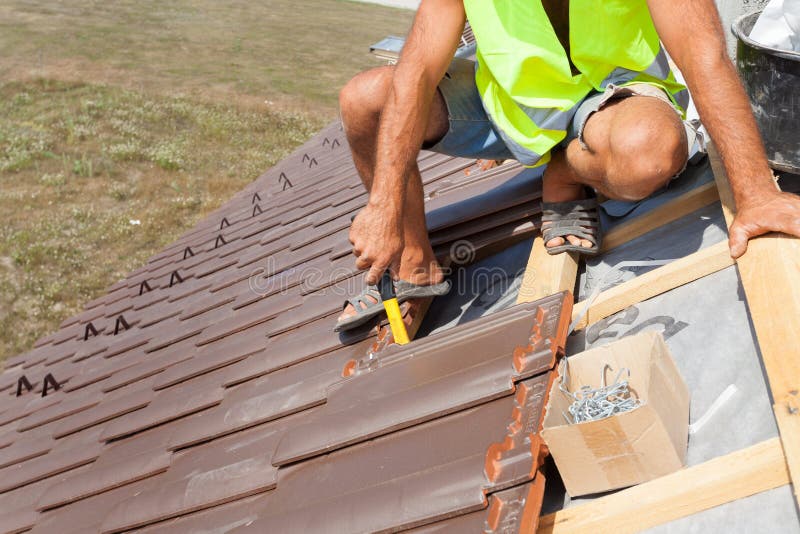 Hands of Roofer Laying Tile on the Roof. Installing Natural Red Tile ...