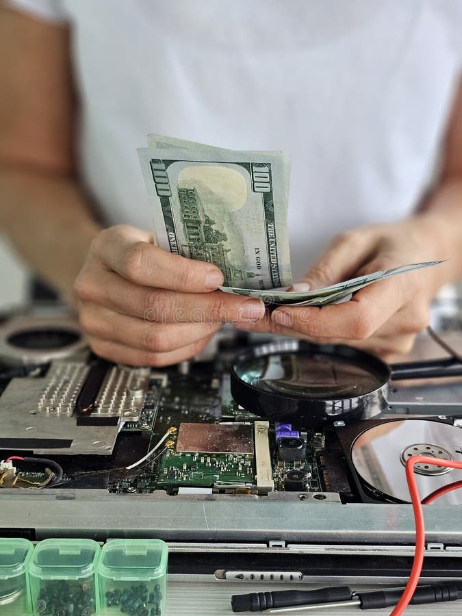 Hands are Seen Counting Cash Above an Opened Electronic Device in ...
