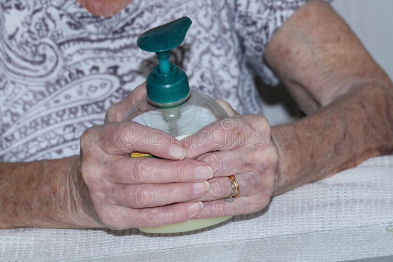 The Hands of a Senior Lady with a Antibacterial Hand Wash Dispenser in ...