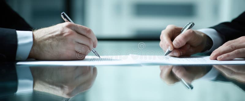 The Hands Signing a Business Contract on a Reflective Table in an ...