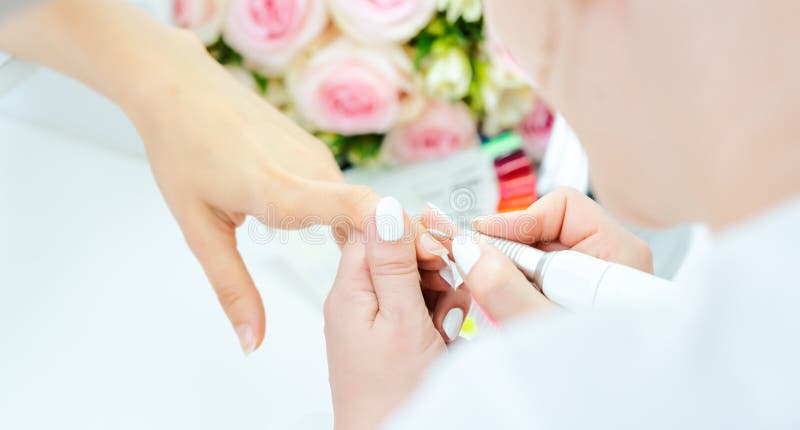 Hands of a Skilled Manicurist Working on Nails of a Young Woman Stock ...