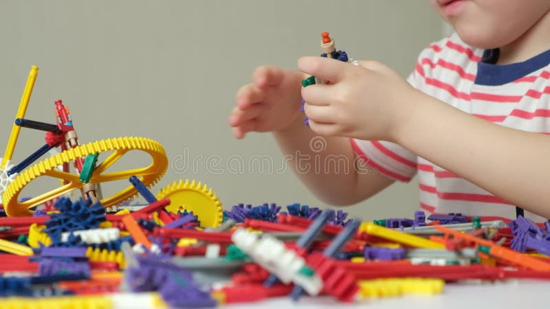 Hands of a Small Child Disassembling a Figure Made of a Constructor ...