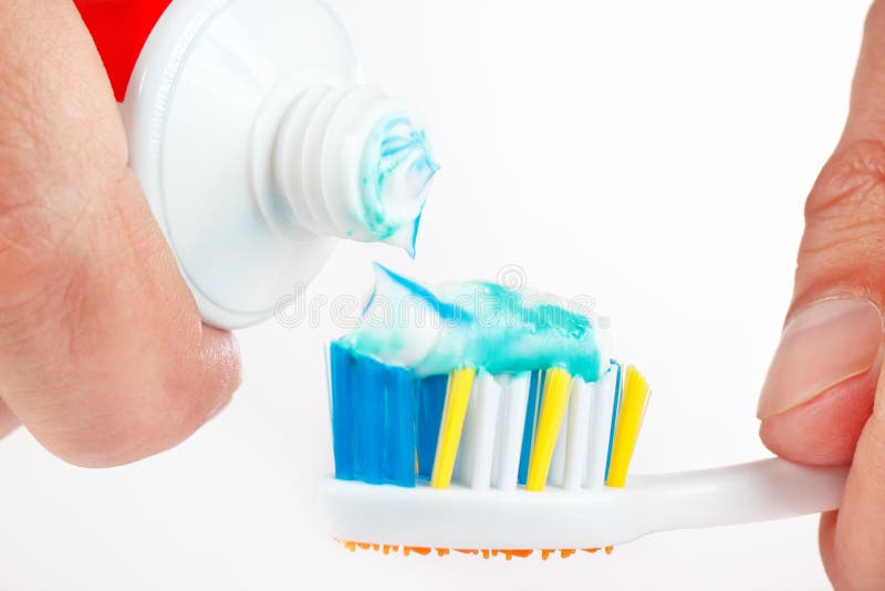 Hands Squeezing Toothpaste from a Tube on the Toothbrush Stock Image ...