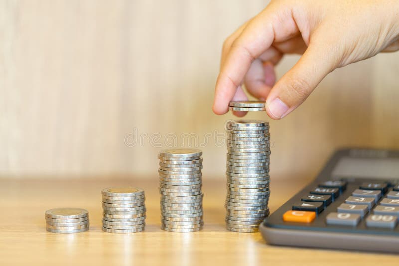 Hands Stacking Money for Growing Chart of Coins with Calculator. Stock ...