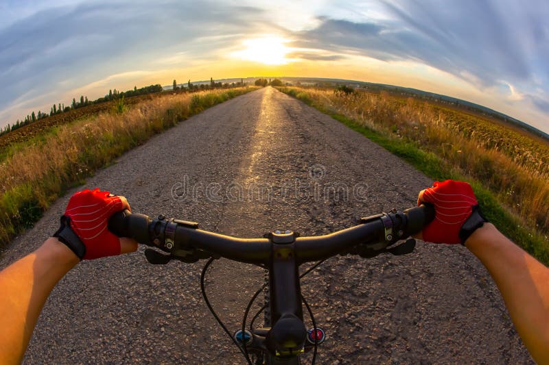 Hands on the Steering Wheel Riding a Cyclist on the Road Towards Sunset ...