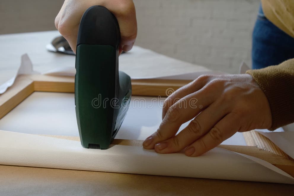 Hands Stretching Canvas on Stretcher Bars Using Staple Gun in Workshop ...