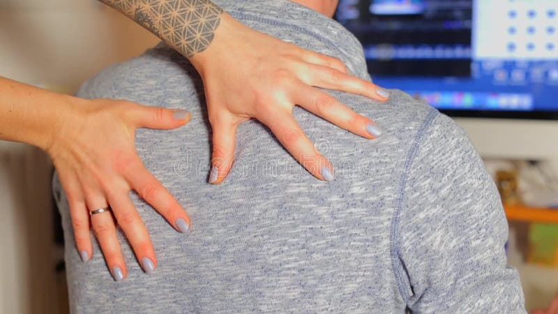 Hands Stroking the Back of a Man Sitting at a Table in the Office ...