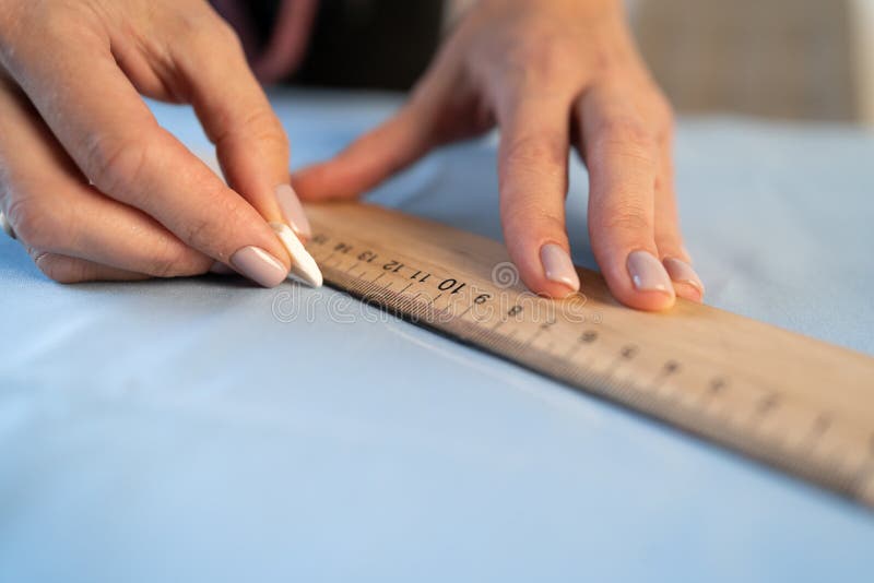 Hands of Tailor Measuring Fabric with a Ruler and White Chalk. Clothing ...