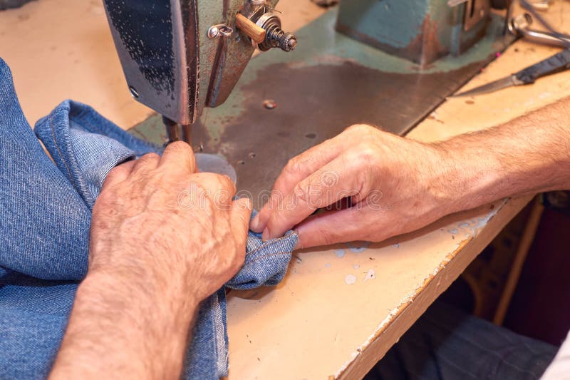 Hands of a Tailor Sewing Blue Jeans on a Sewing Machine Stock Image ...