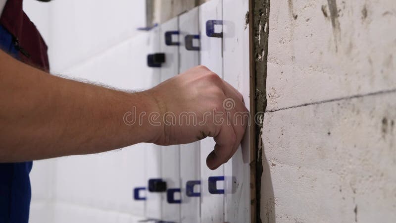 The Hands of the Tiler are Laying the Ceramic Tile on the Wall Stock ...