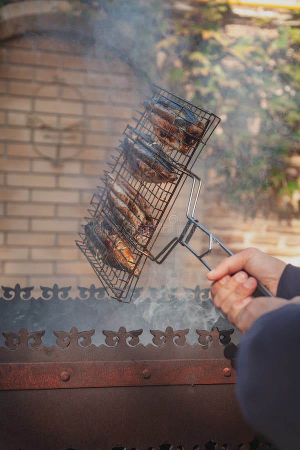 Hands Turn Grill with Fish Over Brazier Stock Image - Image of firewood ...