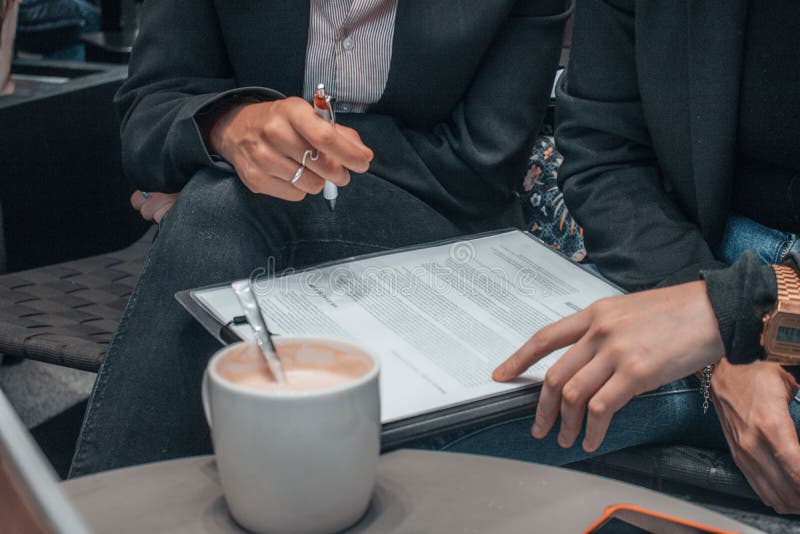 Hands of Two Females Checking a List on Their Lap Stock Image - Image ...