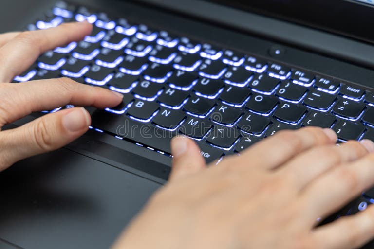 Hands Typing on Backlit Keyboard of Modern Laptop in Close-Up View ...