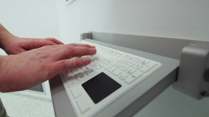 Hands Typing on a Modern Wall-mounted Keyboard in a Clean and Sterile ...