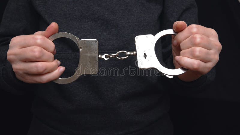 The Hands of an Unknown Man are Holding Steel Handcuffs. the Handcuffs ...