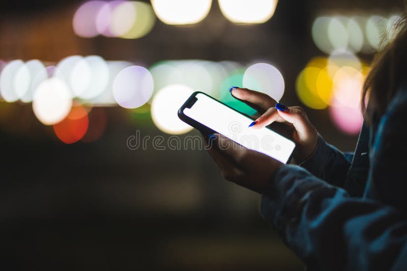 Hands Using Cellphone at Night with Defocused City Lights in the ...