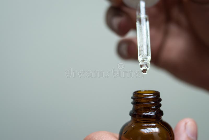 Hands Using a Dark Glass Dropper Stock Photo - Image of pharmacy ...