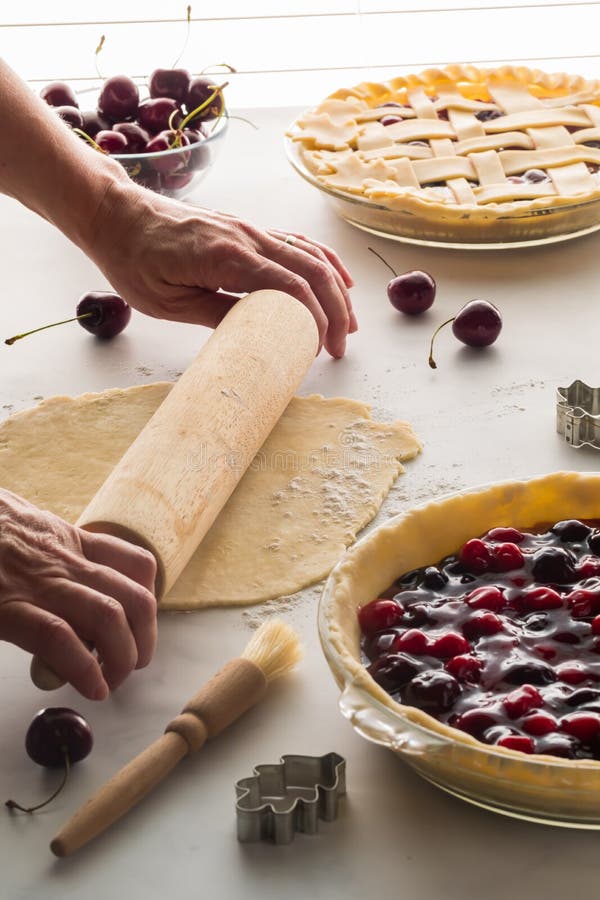 Hands Using a Rolling Pin To Roll Out a Pie Shell To Prepare a Cherry ...